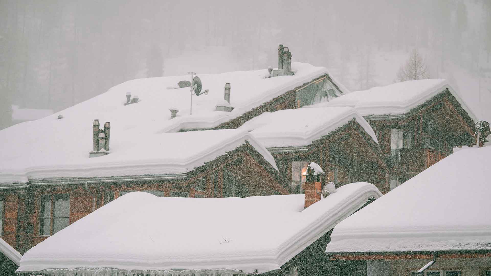Snow piling up on the red roof